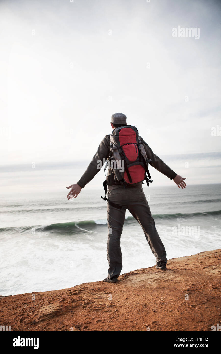 Hiker on the edge of cliff with arms outstretched hi-res stock ...