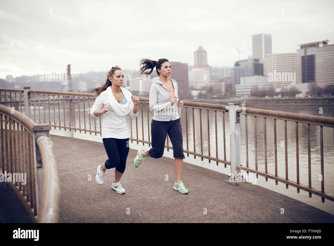 Women running on bridge Stock Photo - Alamy