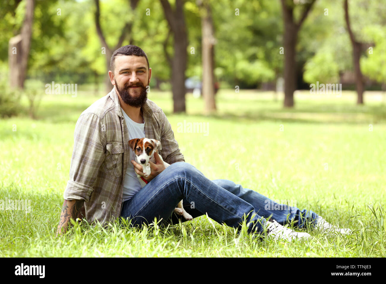 Man with cute dog in spring park Stock Photo - Alamy