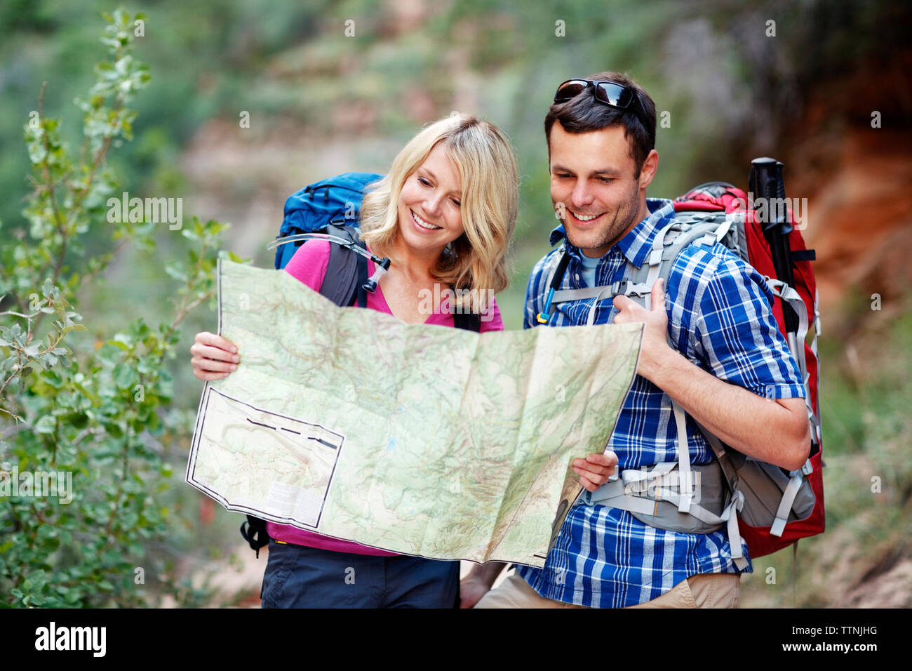 Happy couple checking map during hiking Stock Photo - Alamy