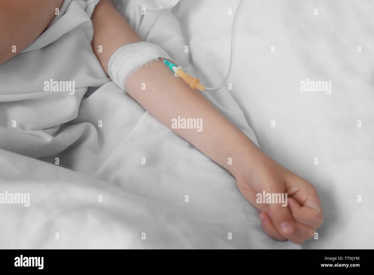 Girl hand with drip infusion on bed Stock Photo - Alamy