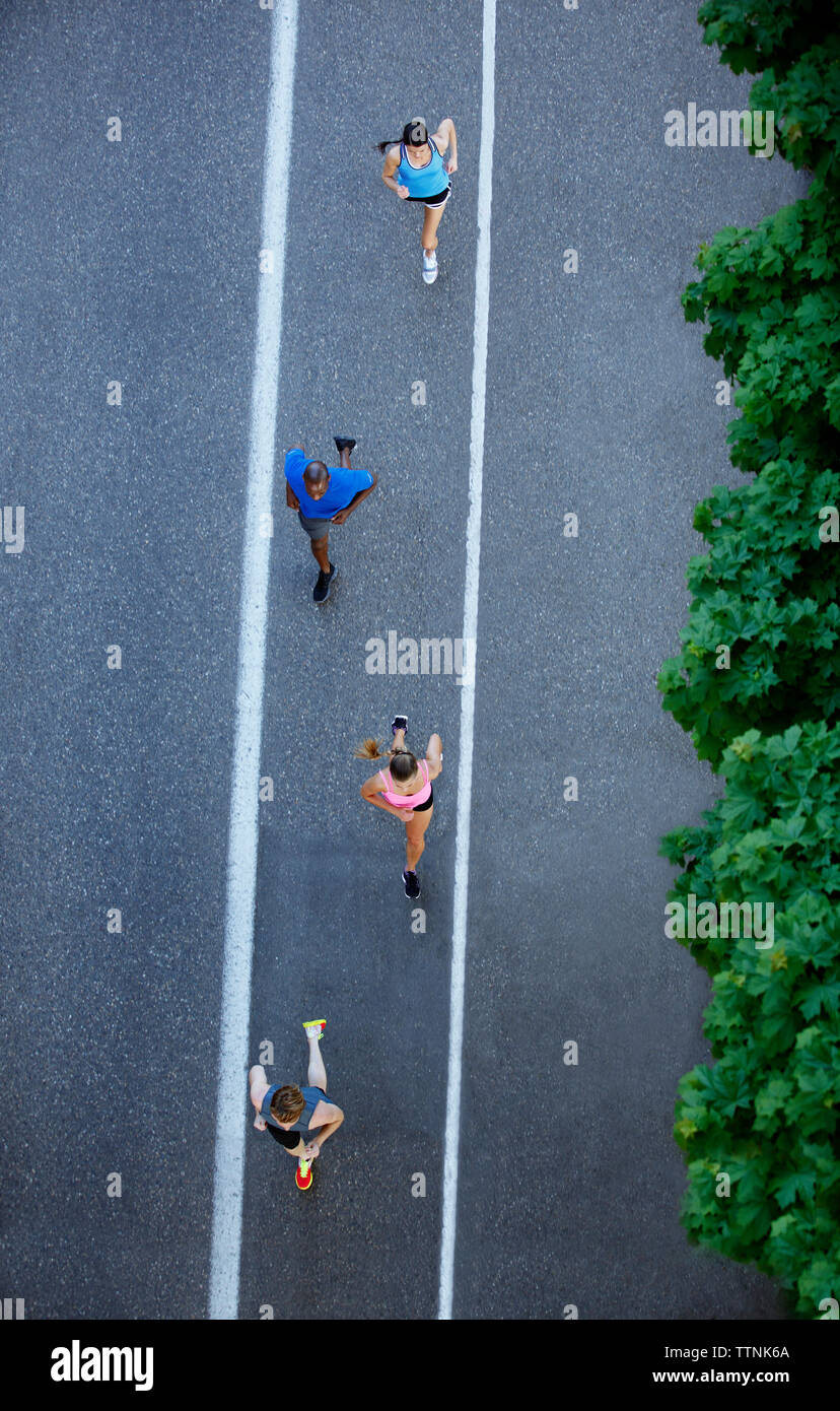 High angle view of athlete friends running on city street Stock Photo ...