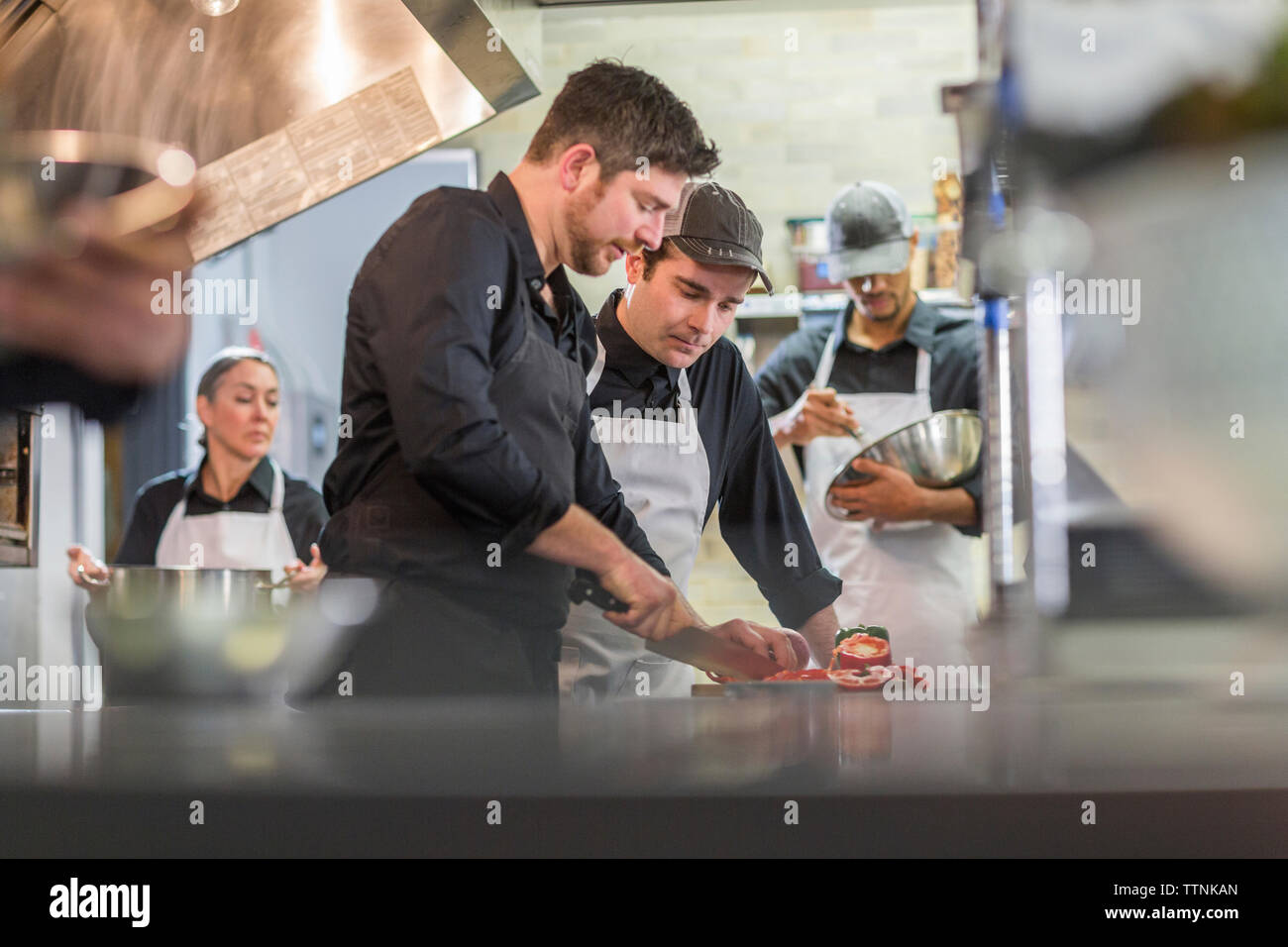 Chefs preparing food in restaurant kitchen Stock Photo - Alamy