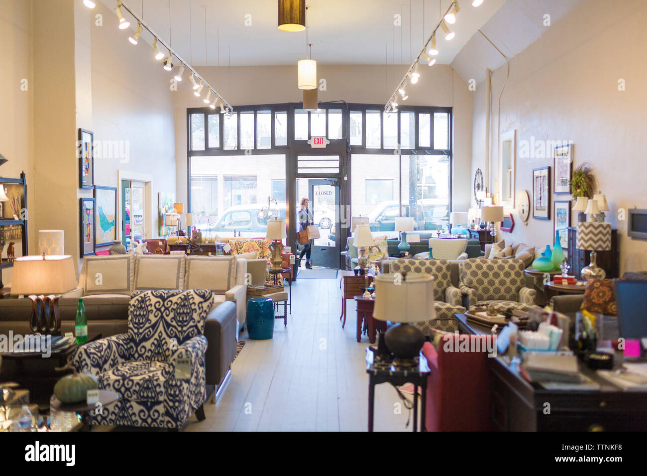 Female customer entering furniture store Stock Photo - Alamy