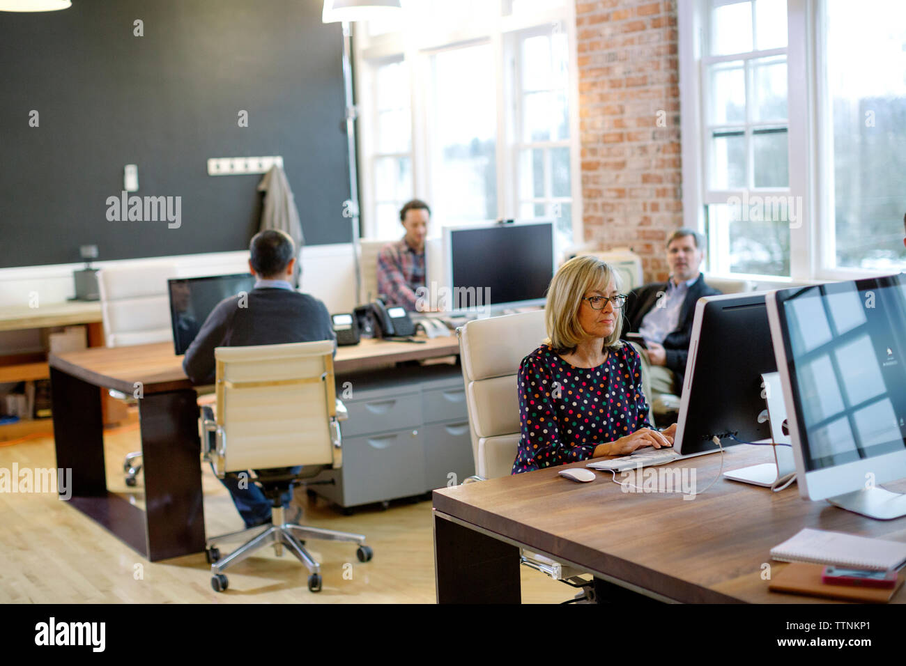 Woman colleagues sitting desks hi-res stock photography and images - Alamy