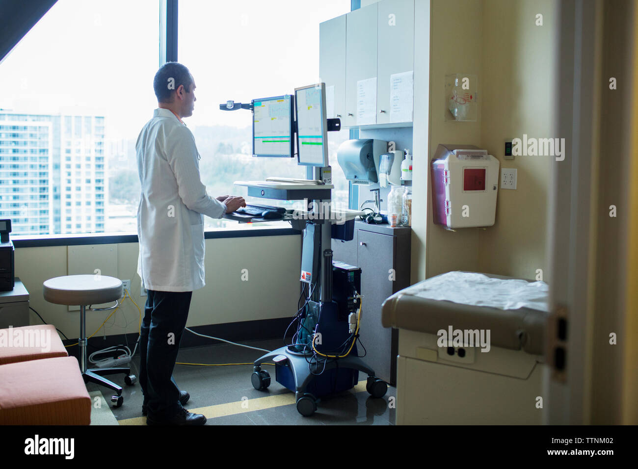 Male doctor using desktop computer in hospital ward Stock Photo - Alamy