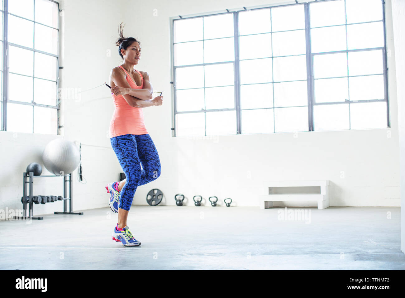 Female athlete exercising with jumping rope in gym Stock Photo - Alamy