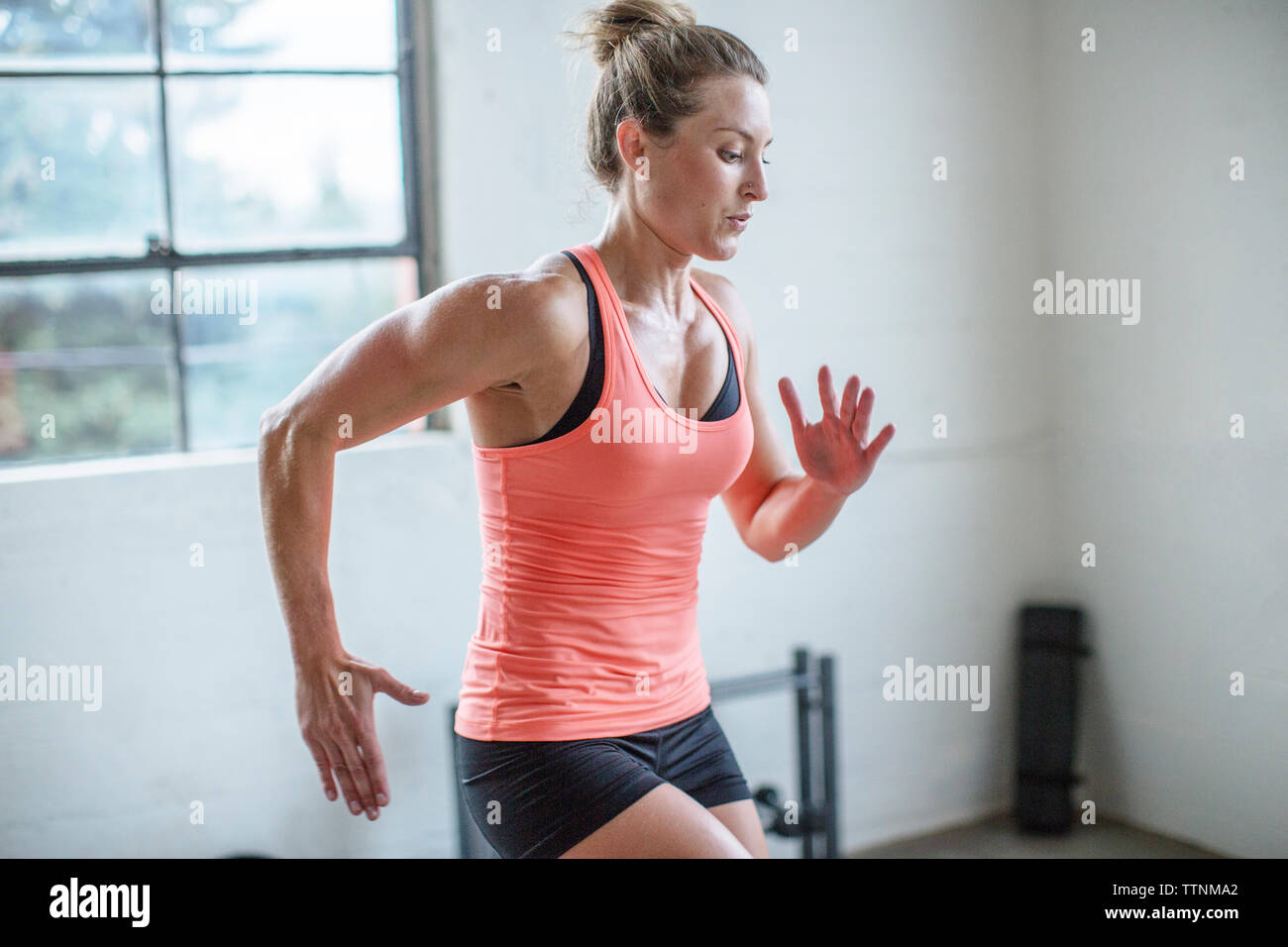 Female athlete jumping in health club Stock Photo - Alamy