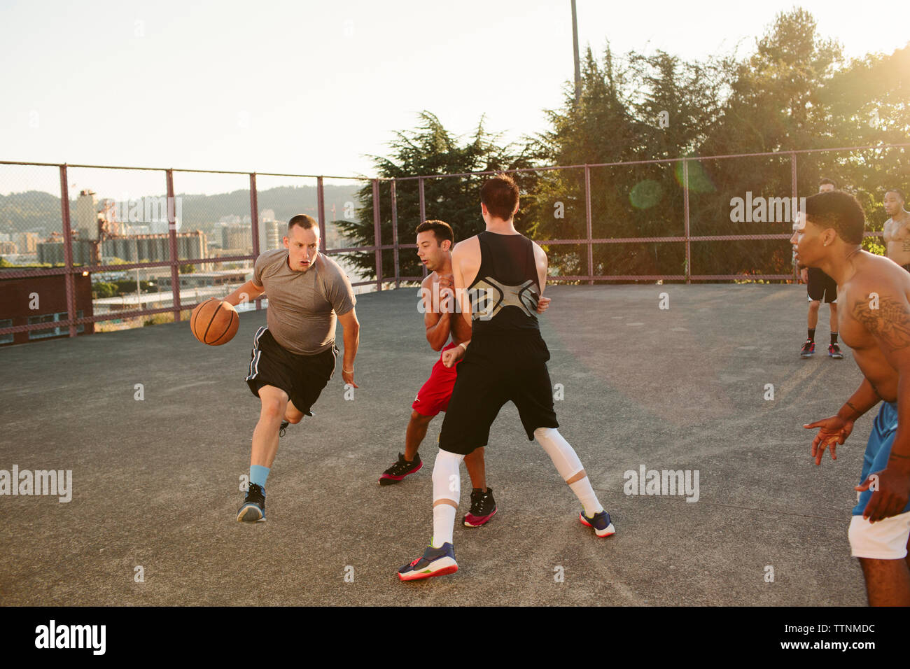Friends playing basketball in court Stock Photo - Alamy