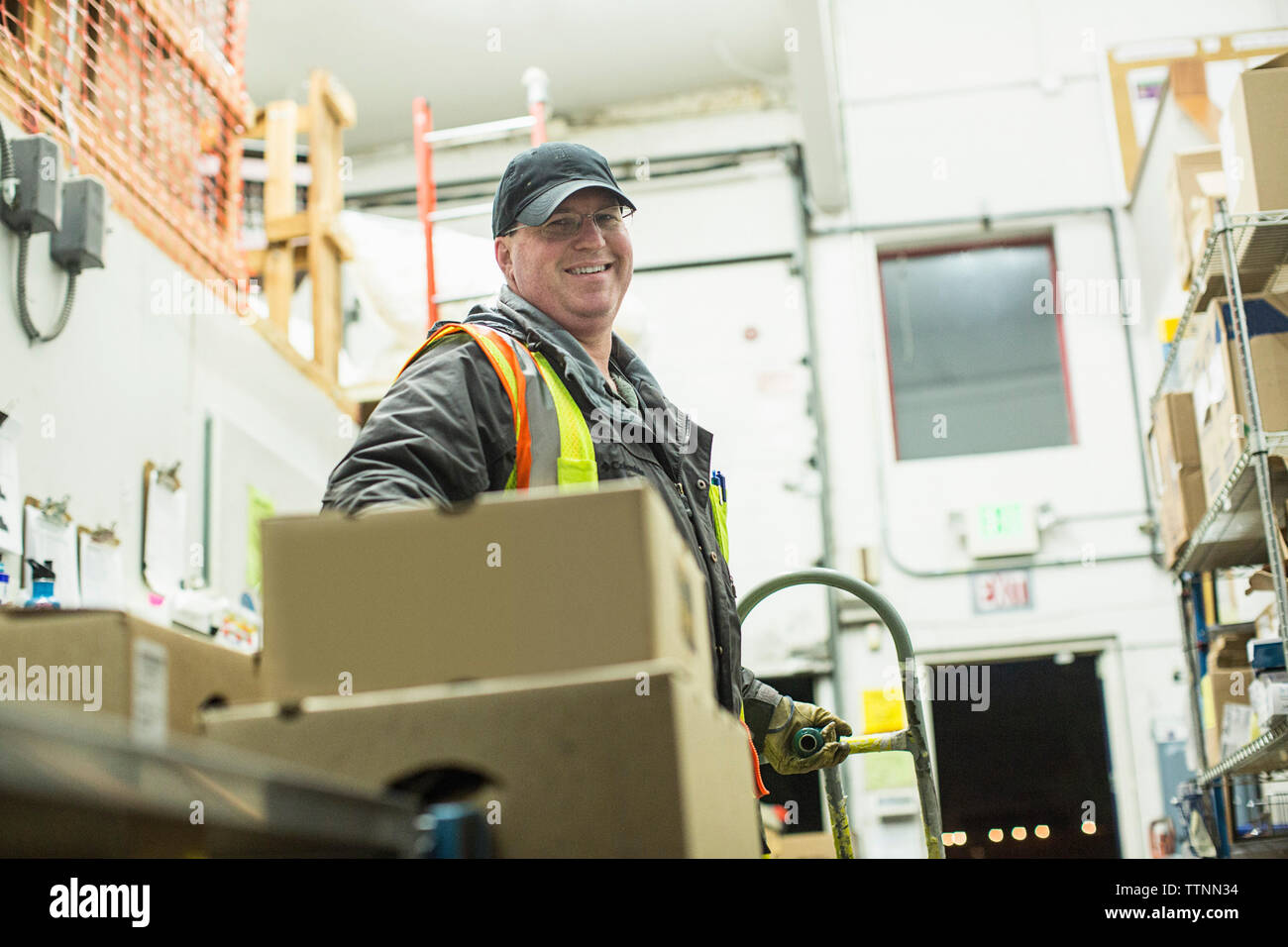 Portrait of smiling worker in warehouse Stock Photo - Alamy
