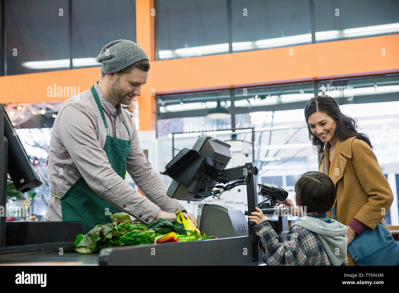 worker making bill while standing with customer at counter in ...