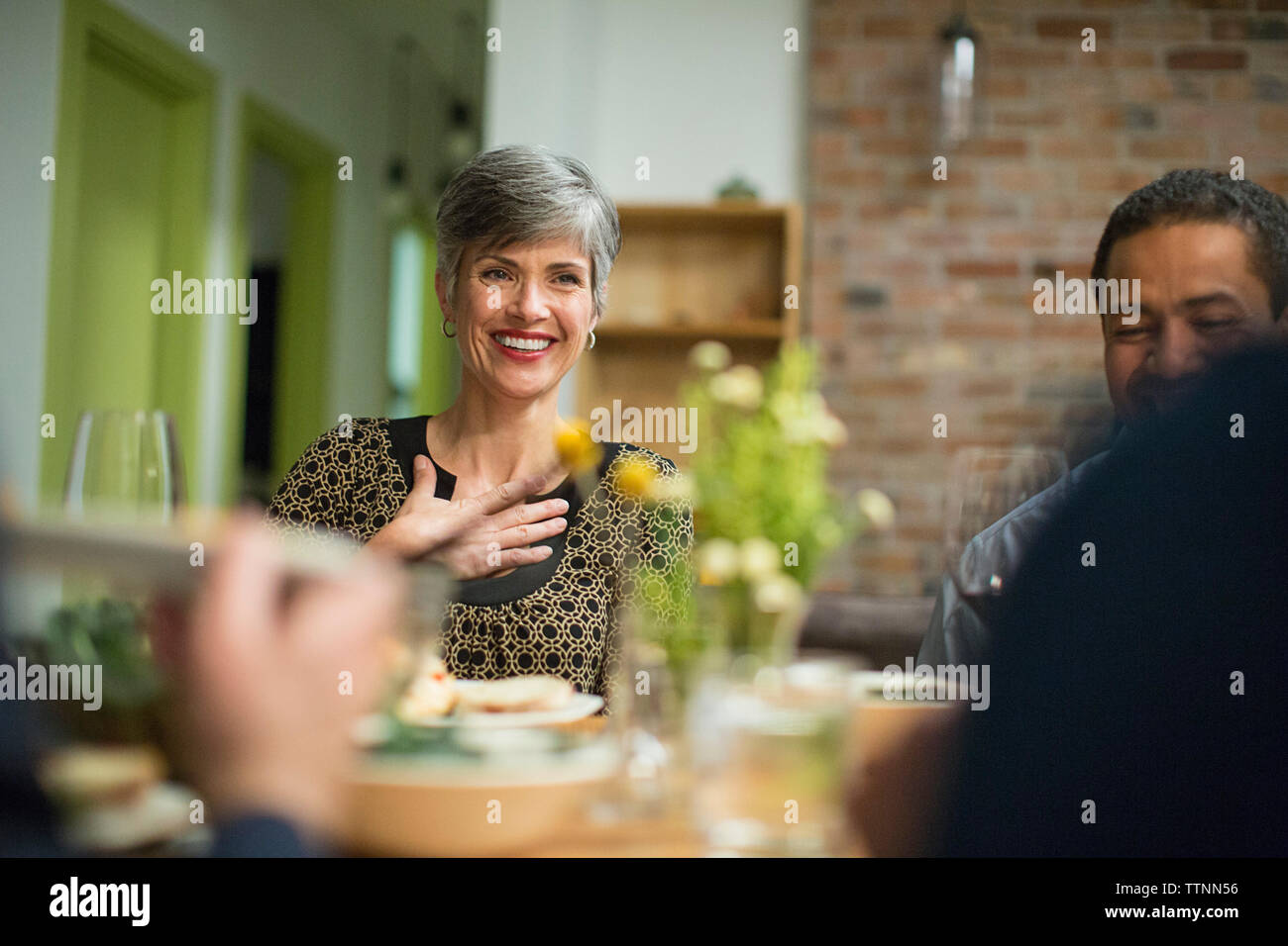 Happy friends at table during social gathering Stock Photo - Alamy