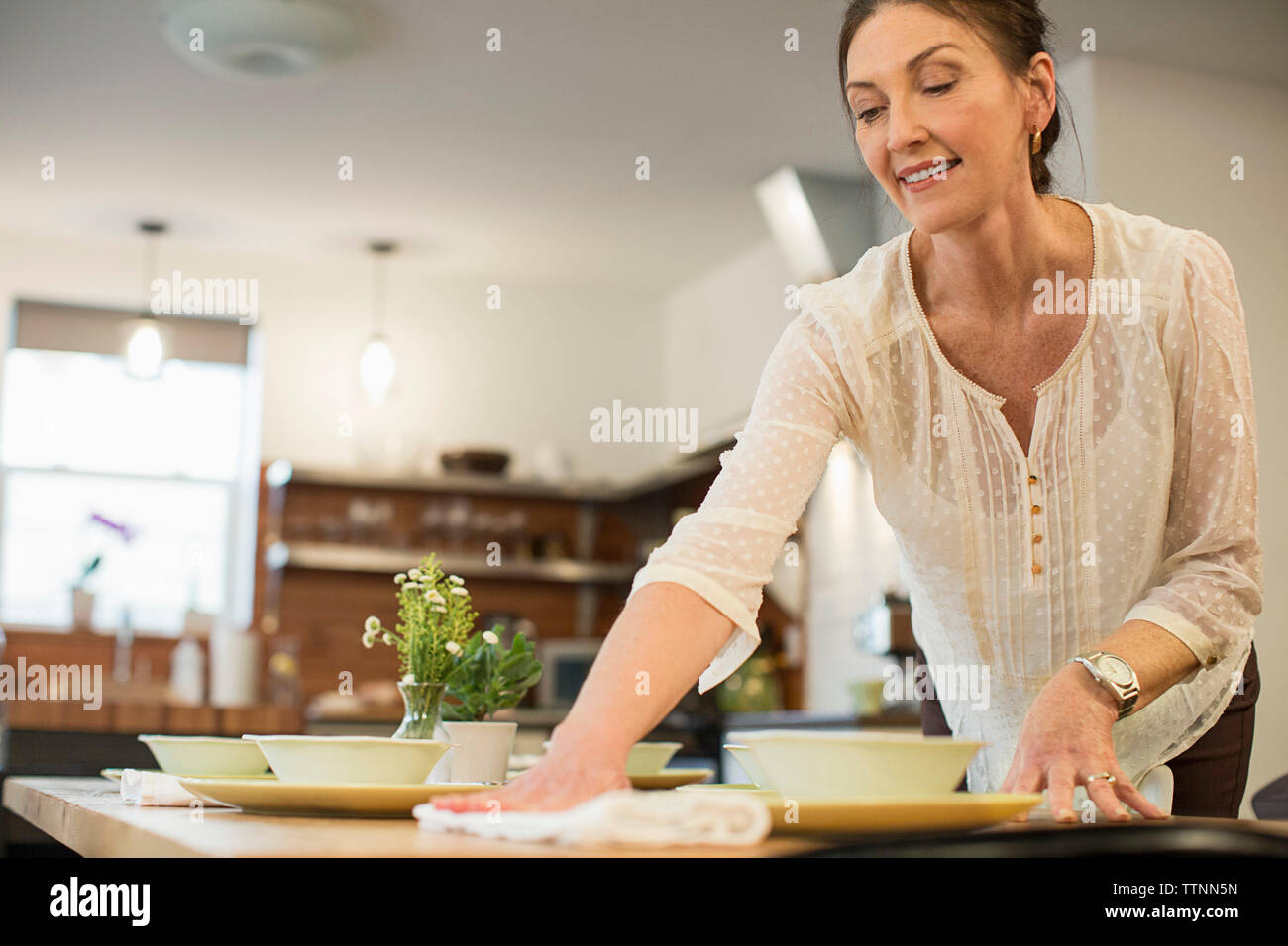 Woman arranging table at home Stock Photo - Alamy
