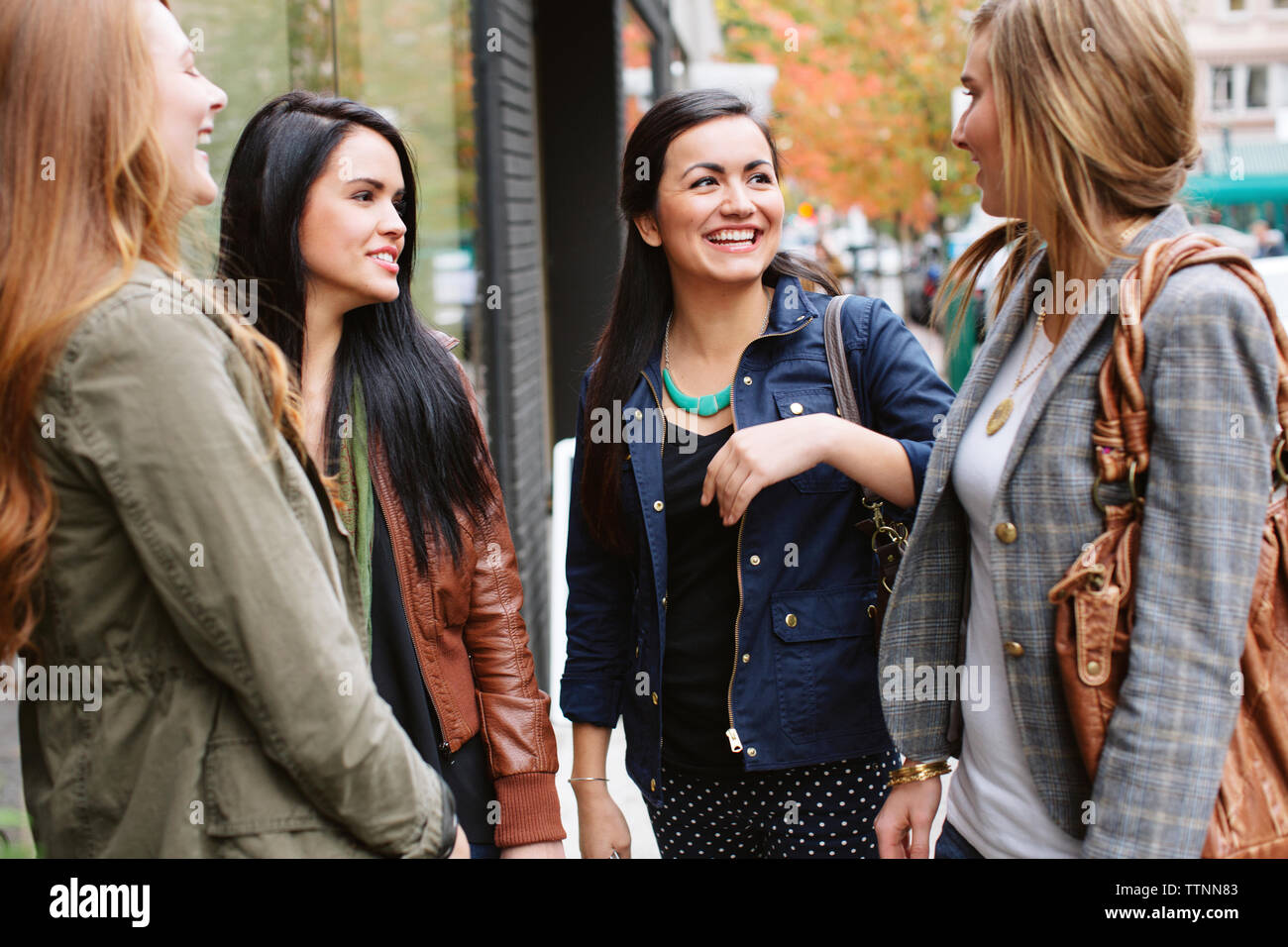 Happy female friends talking while standing by restaurant Stock Photo ...