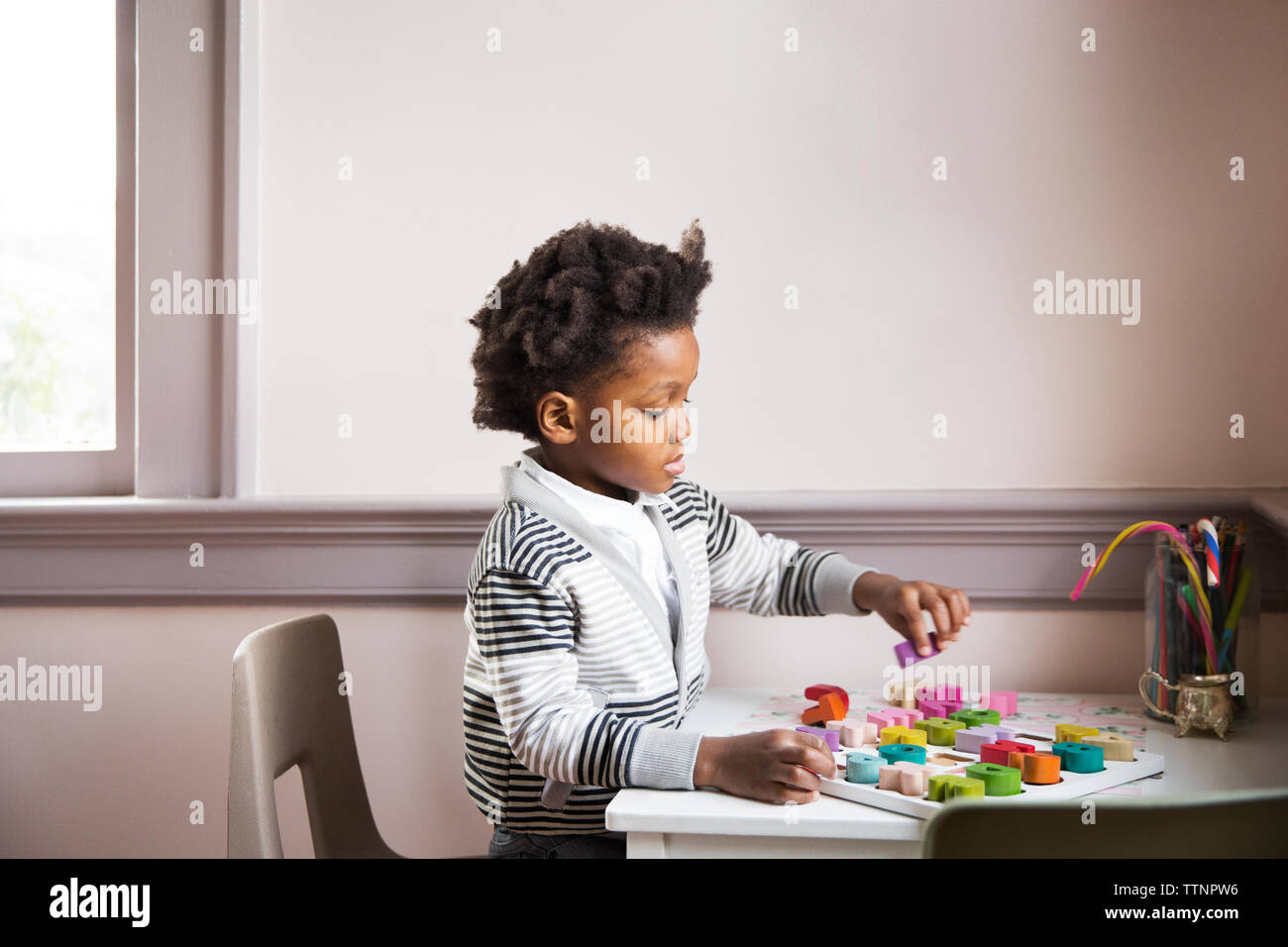 Boy solving alphabet puzzle at home Stock Photo - Alamy