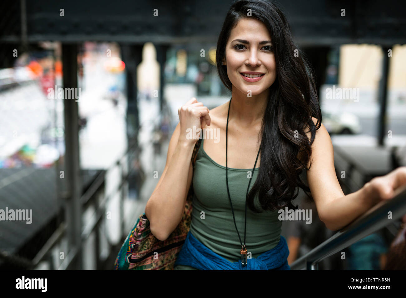 Portrait of smiling woman moving up steps Stock Photo - Alamy