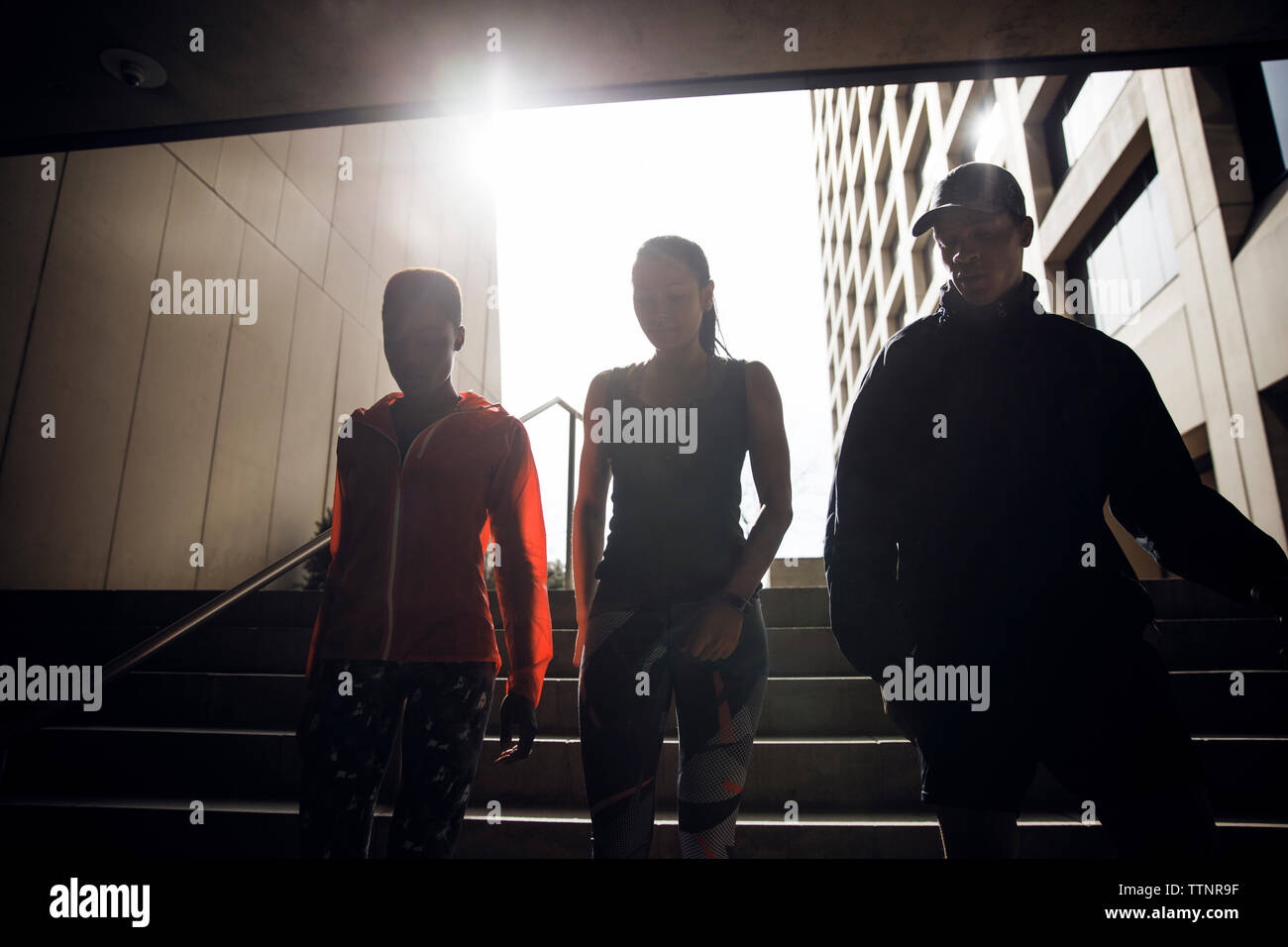 Low angle view of athletes running down steps in subway Stock Photo - Alamy