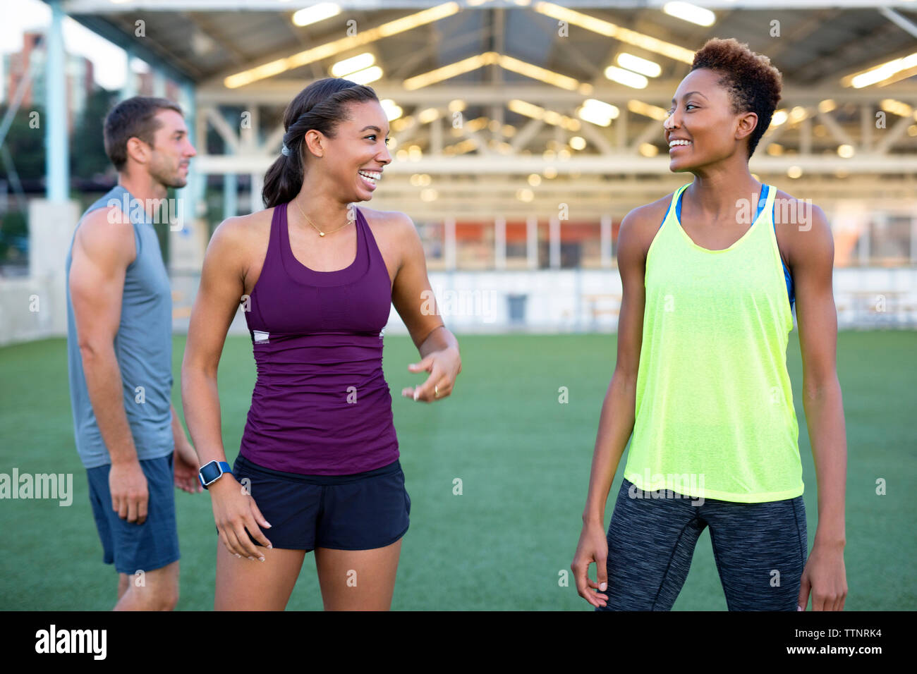 Happy athlete friends standing on field Stock Photo - Alamy