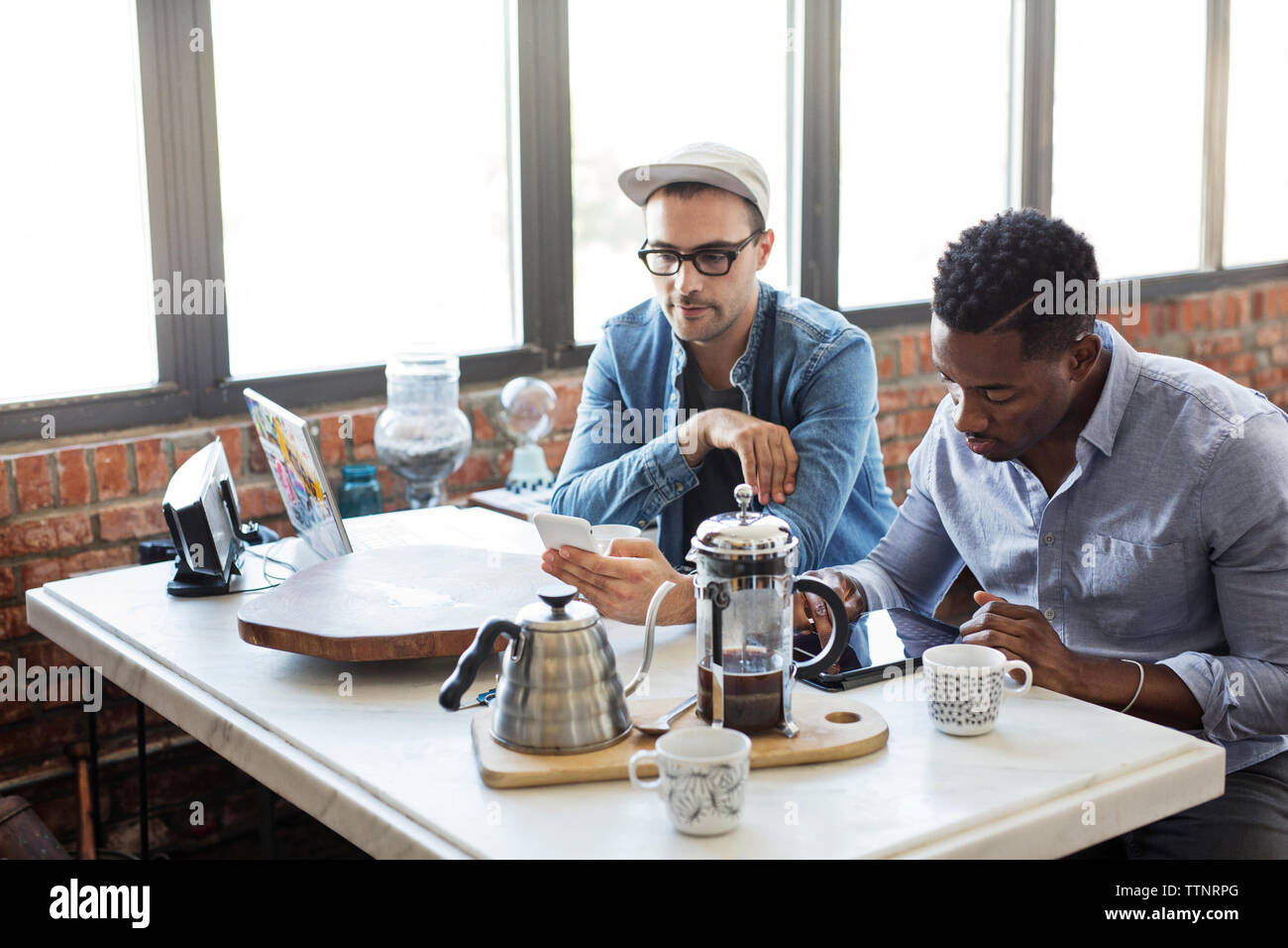 Male friends at dining table Stock Photo - Alamy