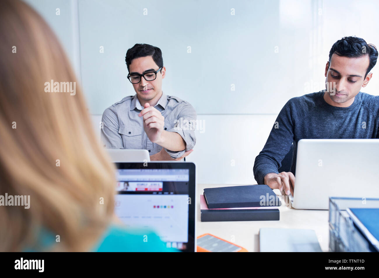Serious business people using laptop computers during meeting at ...