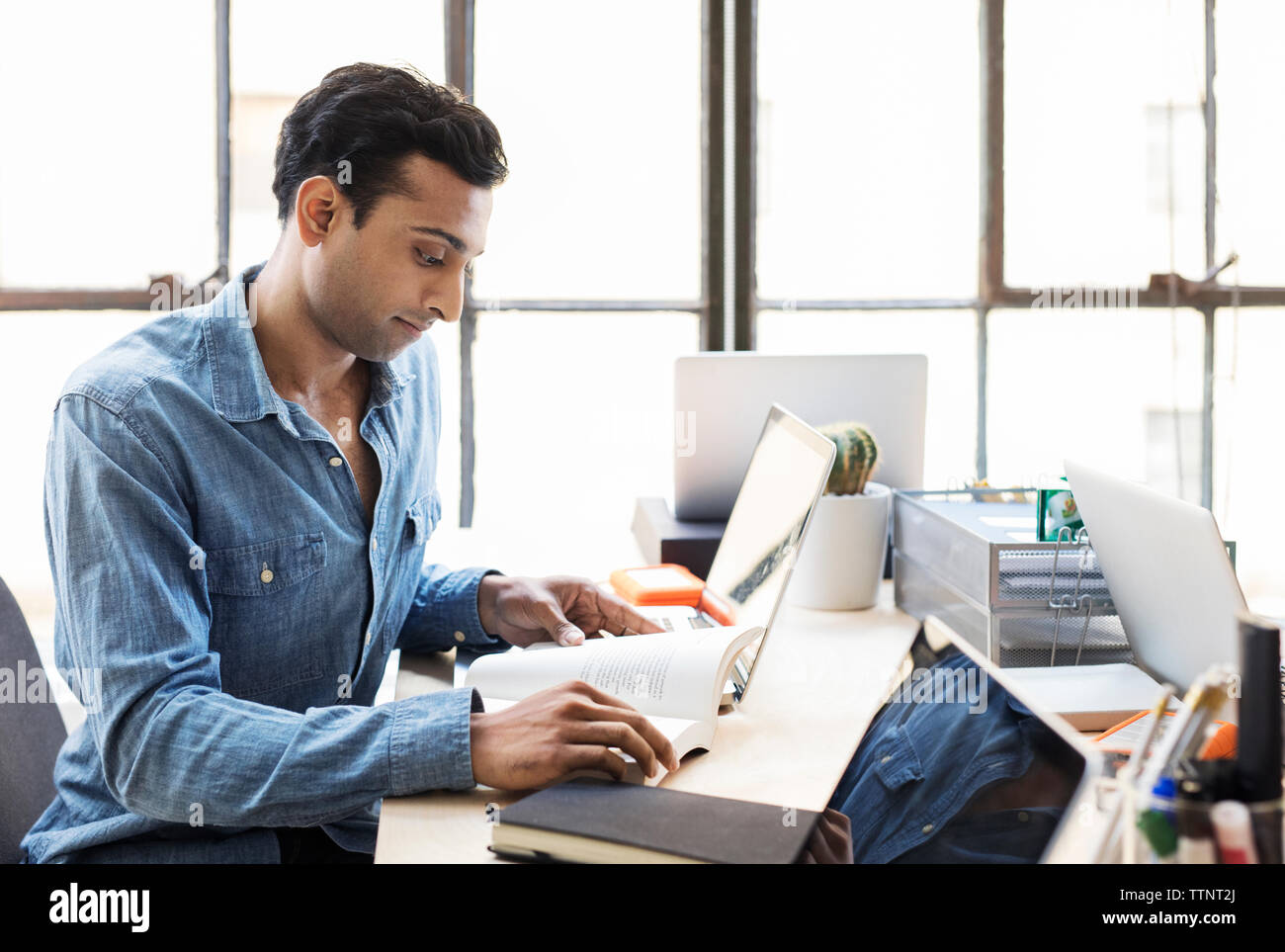 Professional man sitting desk reading hi-res stock photography and ...