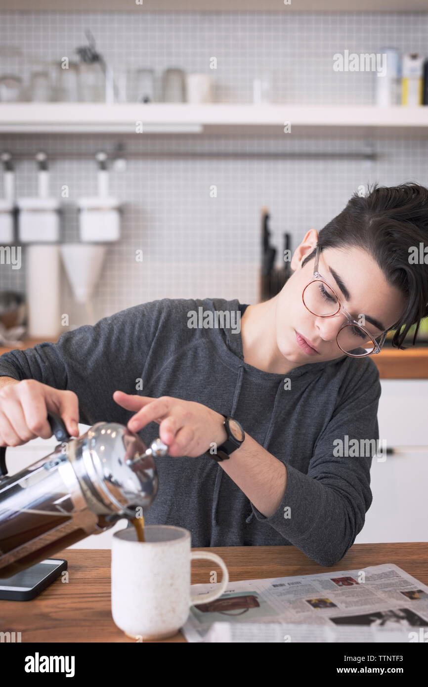 Woman pouring coffee in cup at table Stock Photo - Alamy