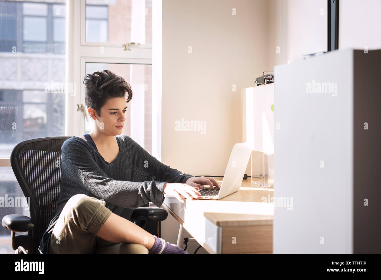 Confident woman using laptop computer at home Stock Photo - Alamy