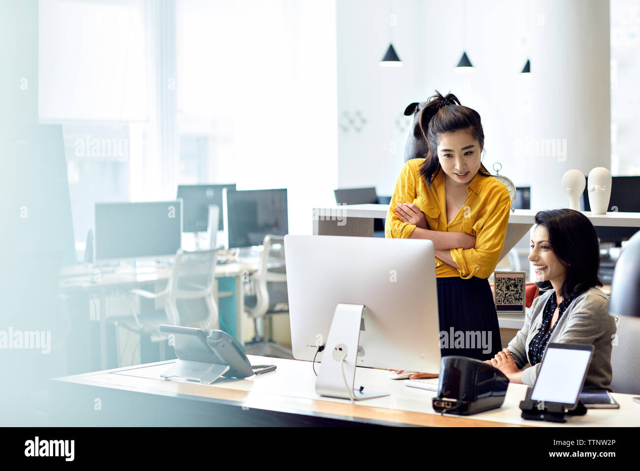 Smiling businesswomen standing arms hi-res stock photography and images ...