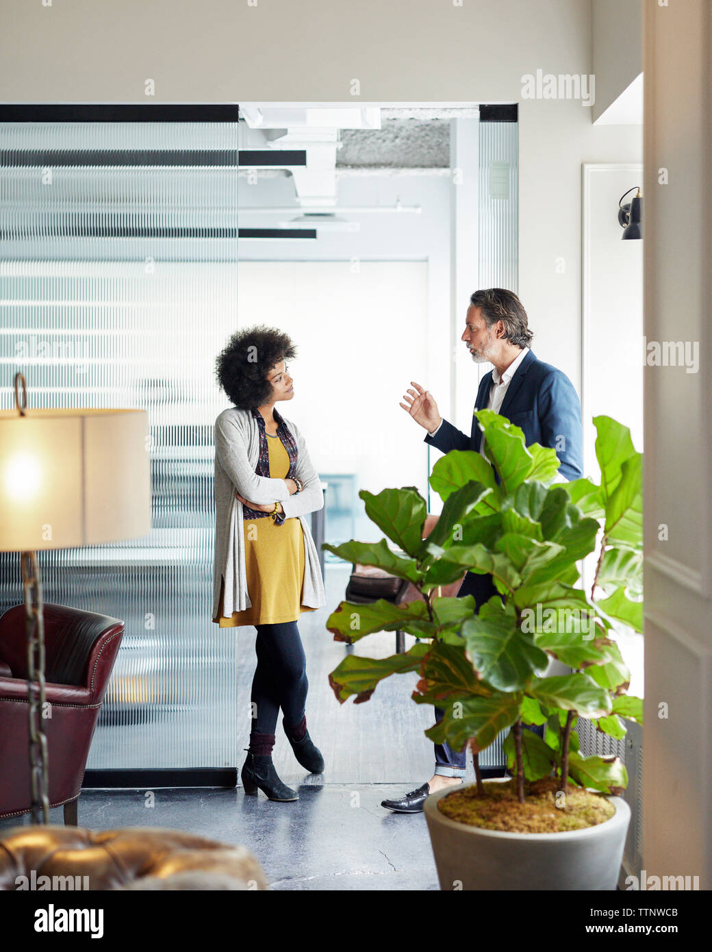 business people talking while standing against door in office Stock ...