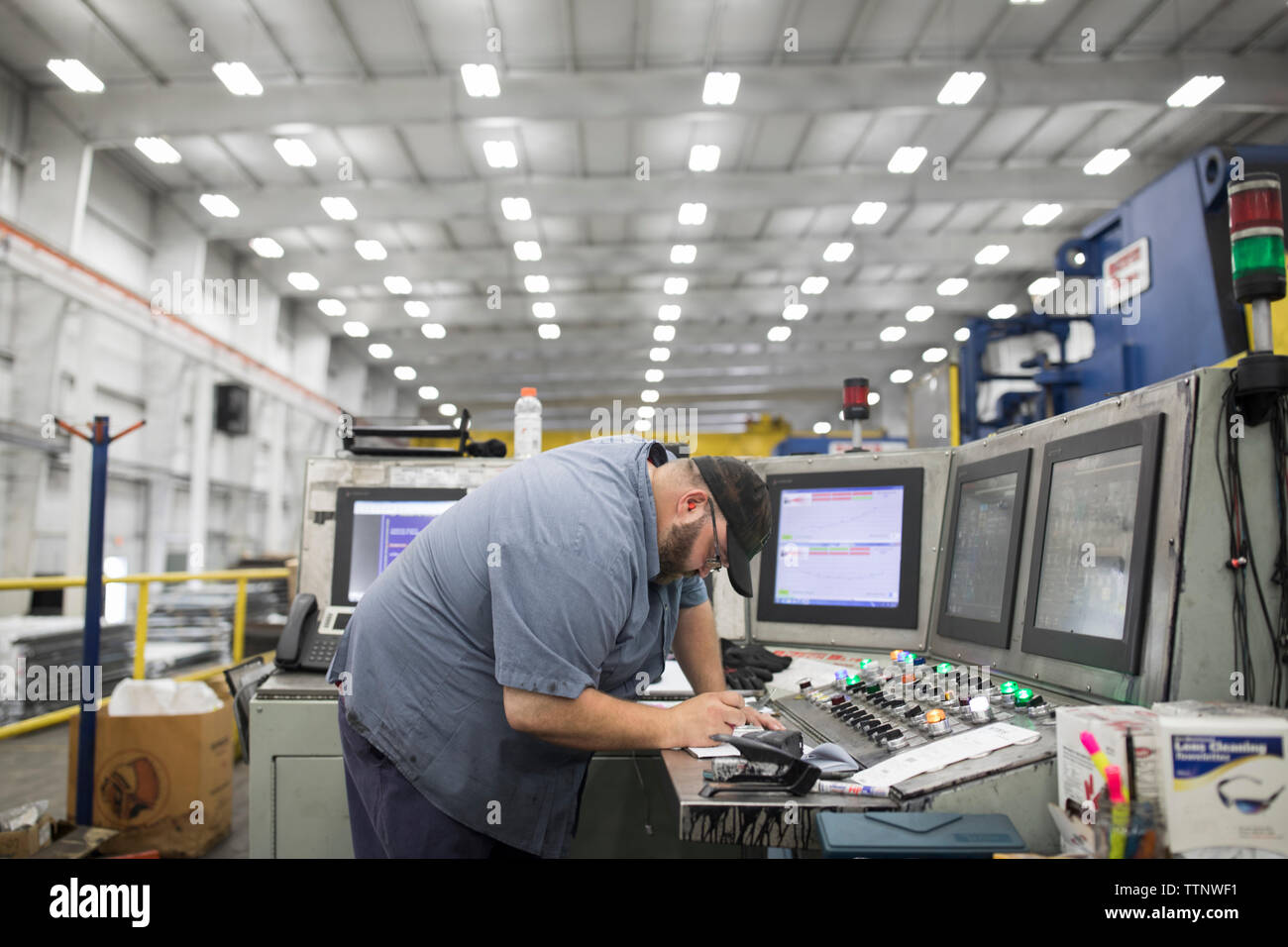 Side view of worker using machine in Steel industry Factory Stock Photo ...