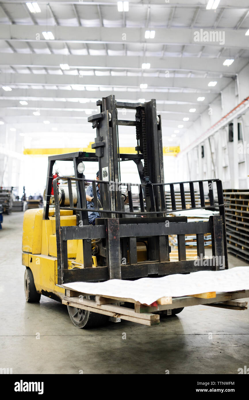 worker driving forklift in warehouse at Steel industry Factory Stock ...