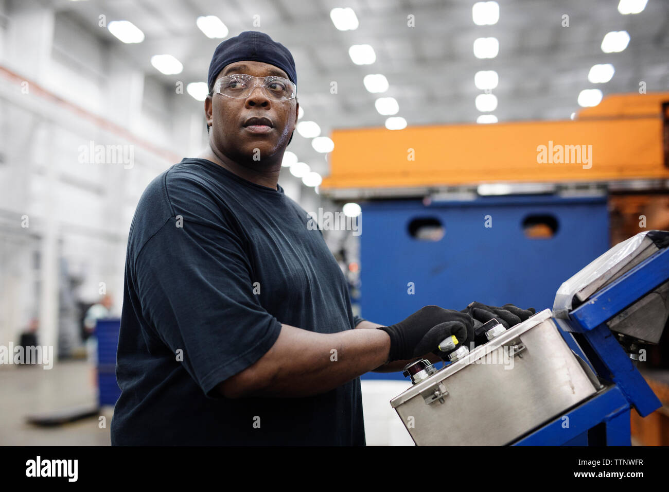 Worker controlling machine while working in Steel Industry Factory ...
