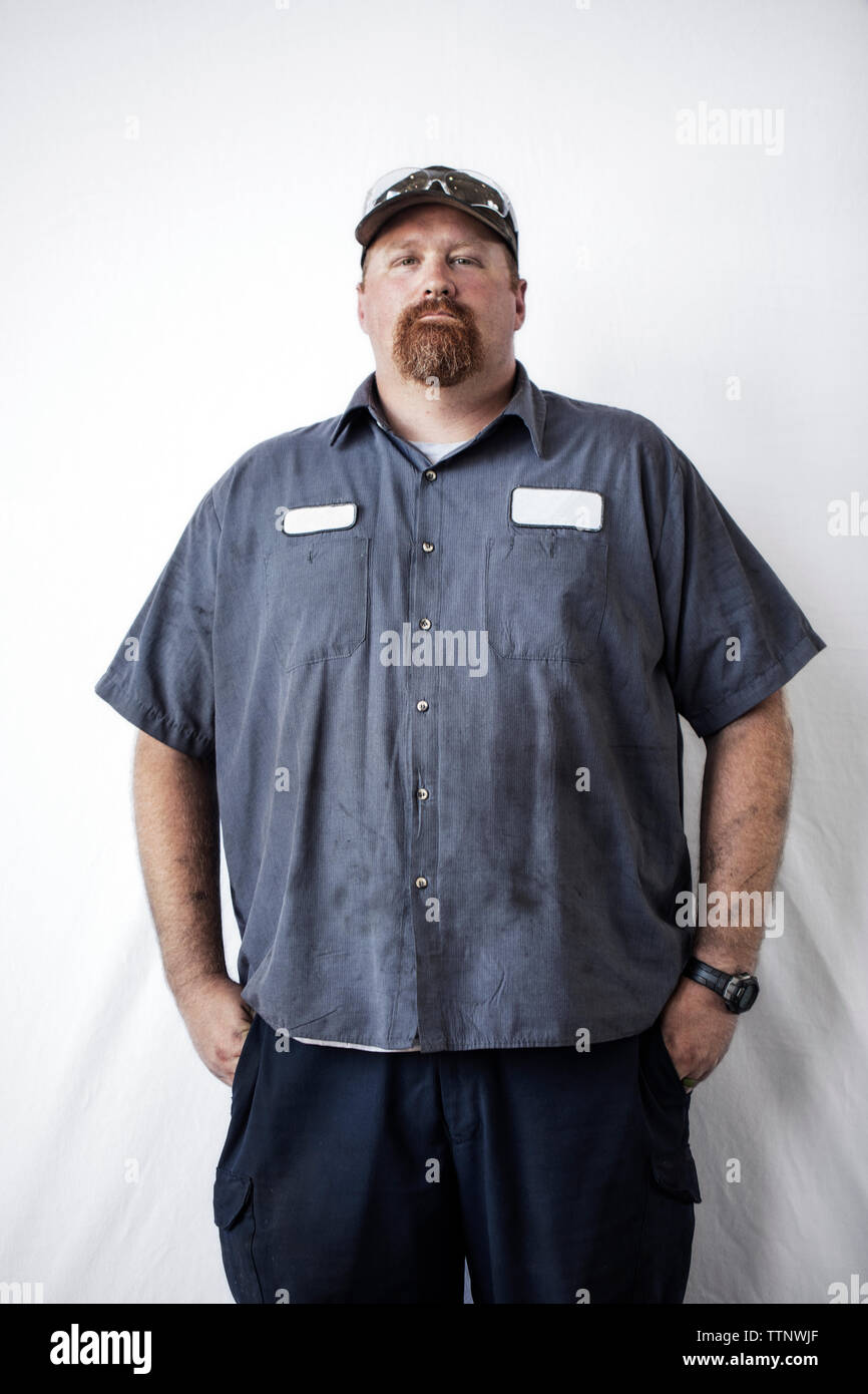 Portrait of confident worker standing against white background Stock ...