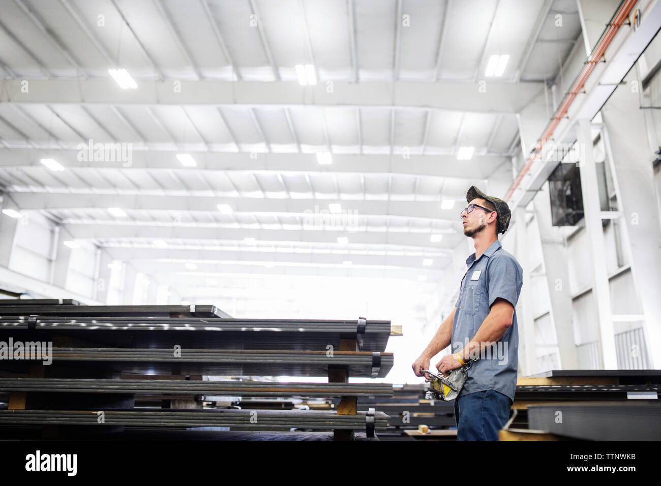 Side view of worker using control in metal Steel Mill Stock Photo - Alamy