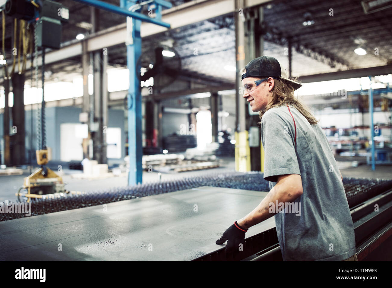 Side view of steel worker working in steel factory Stock Photo - Alamy