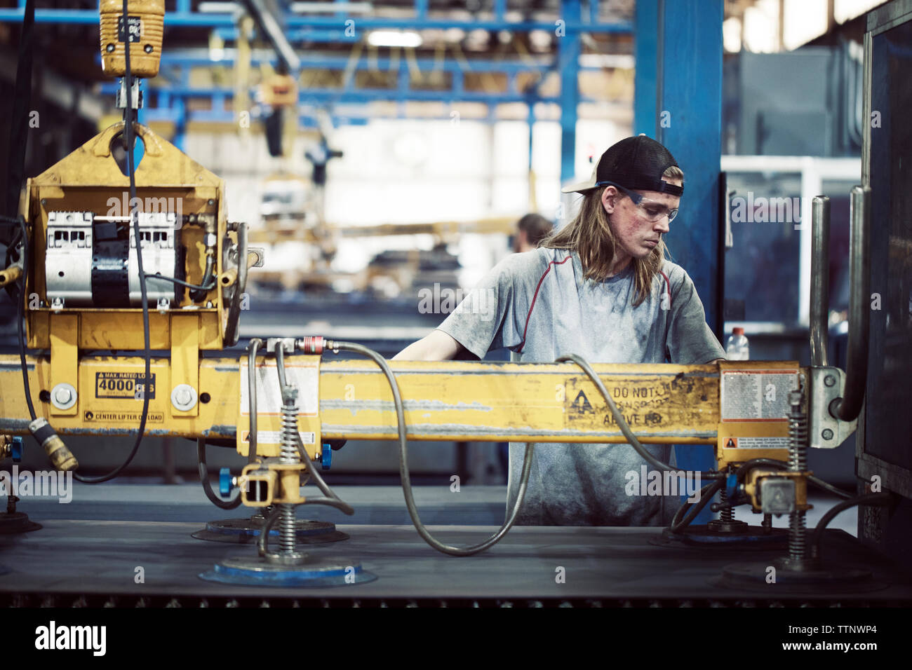 Steel worker using machinery while working in factory Stock Photo - Alamy