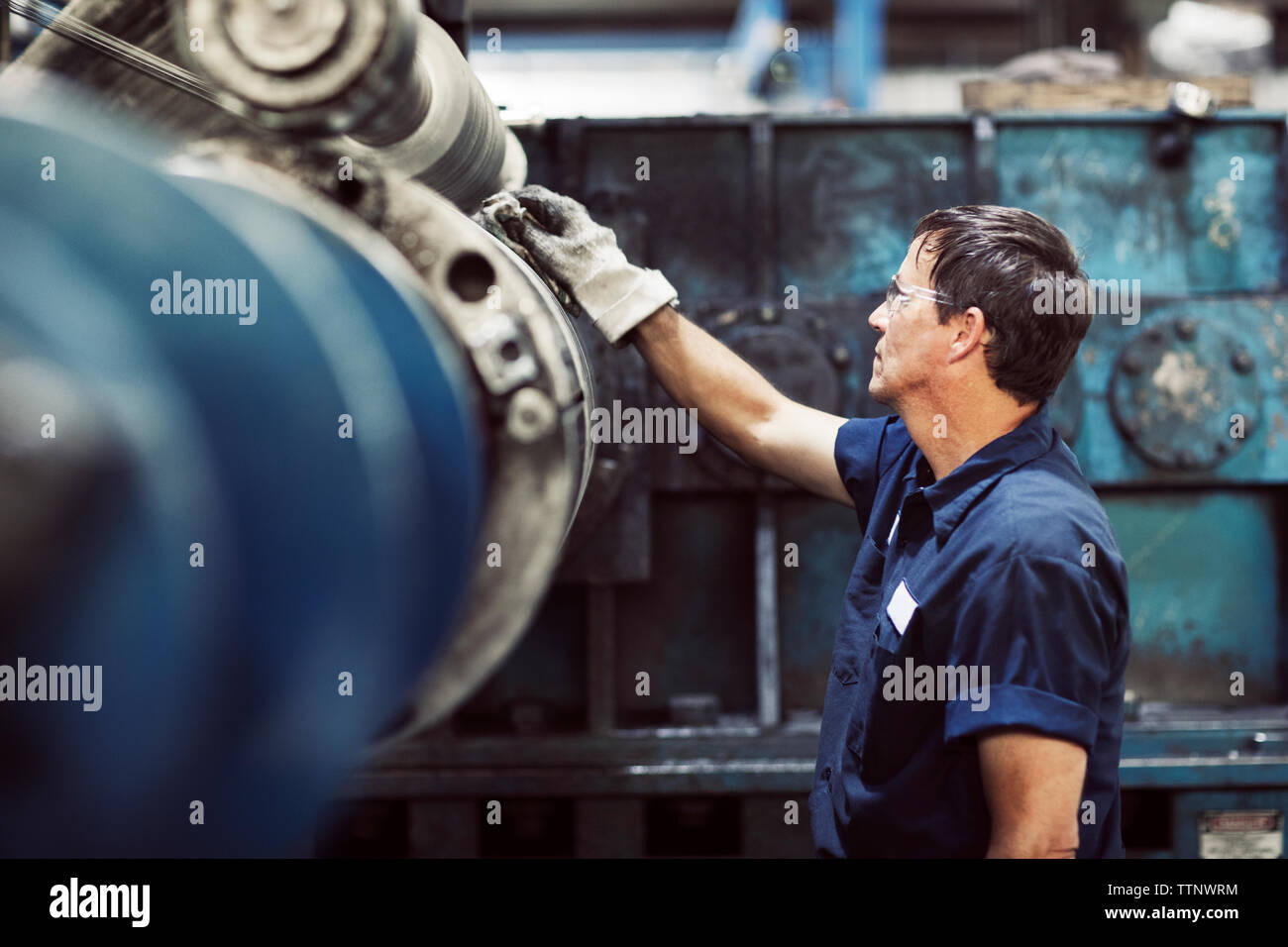 Side view of worker analyzing steel sheets at industry Stock Photo - Alamy