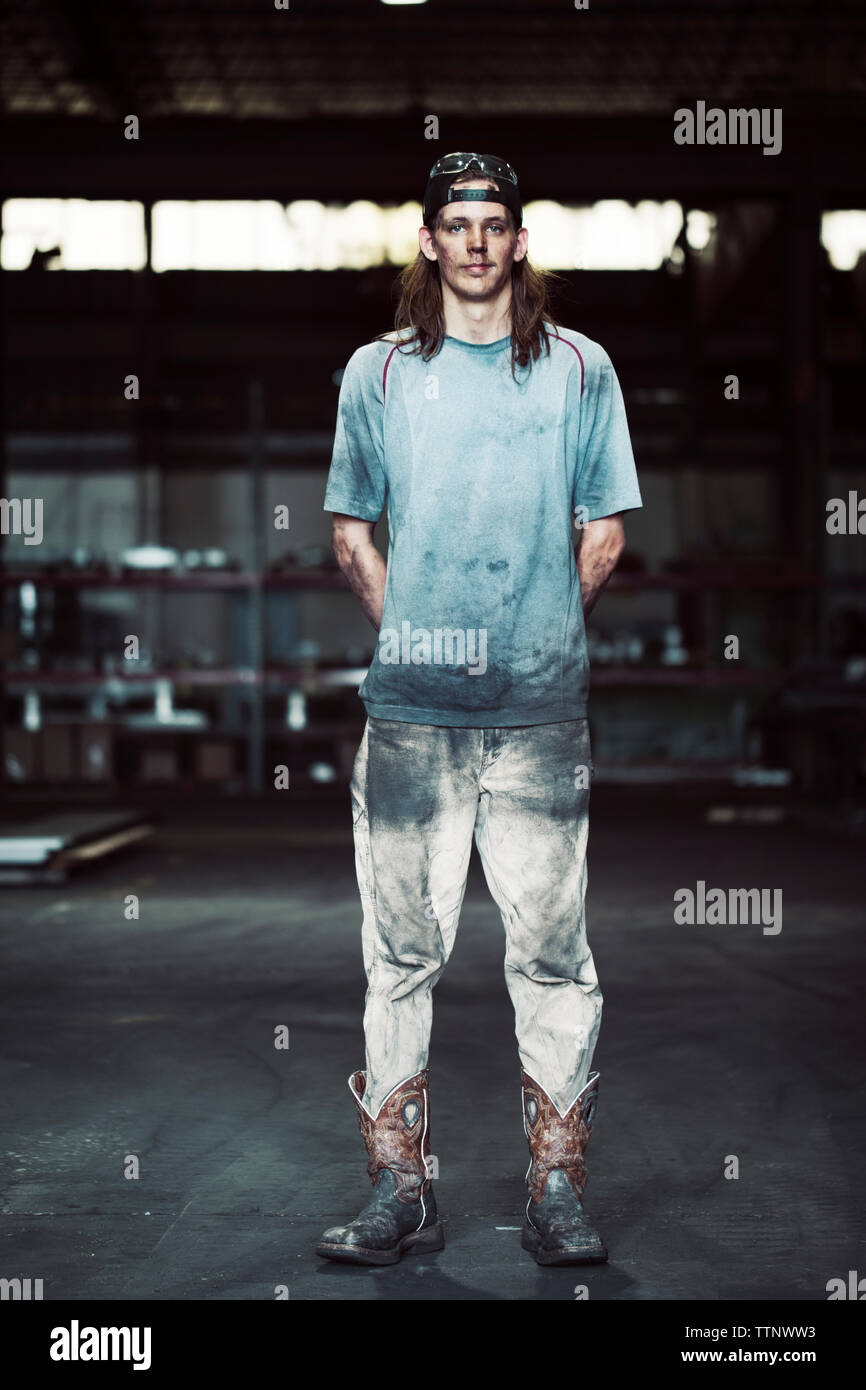 Full length portrait of messy worker standing in industry Stock Photo ...
