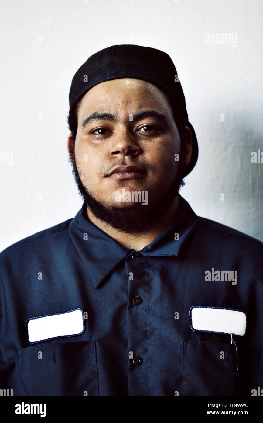 Portrait of young worker wearing uniform against white background Stock ...