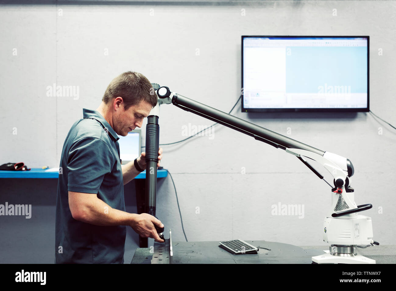 Side view of serious worker working on steel with equipment at industry ...