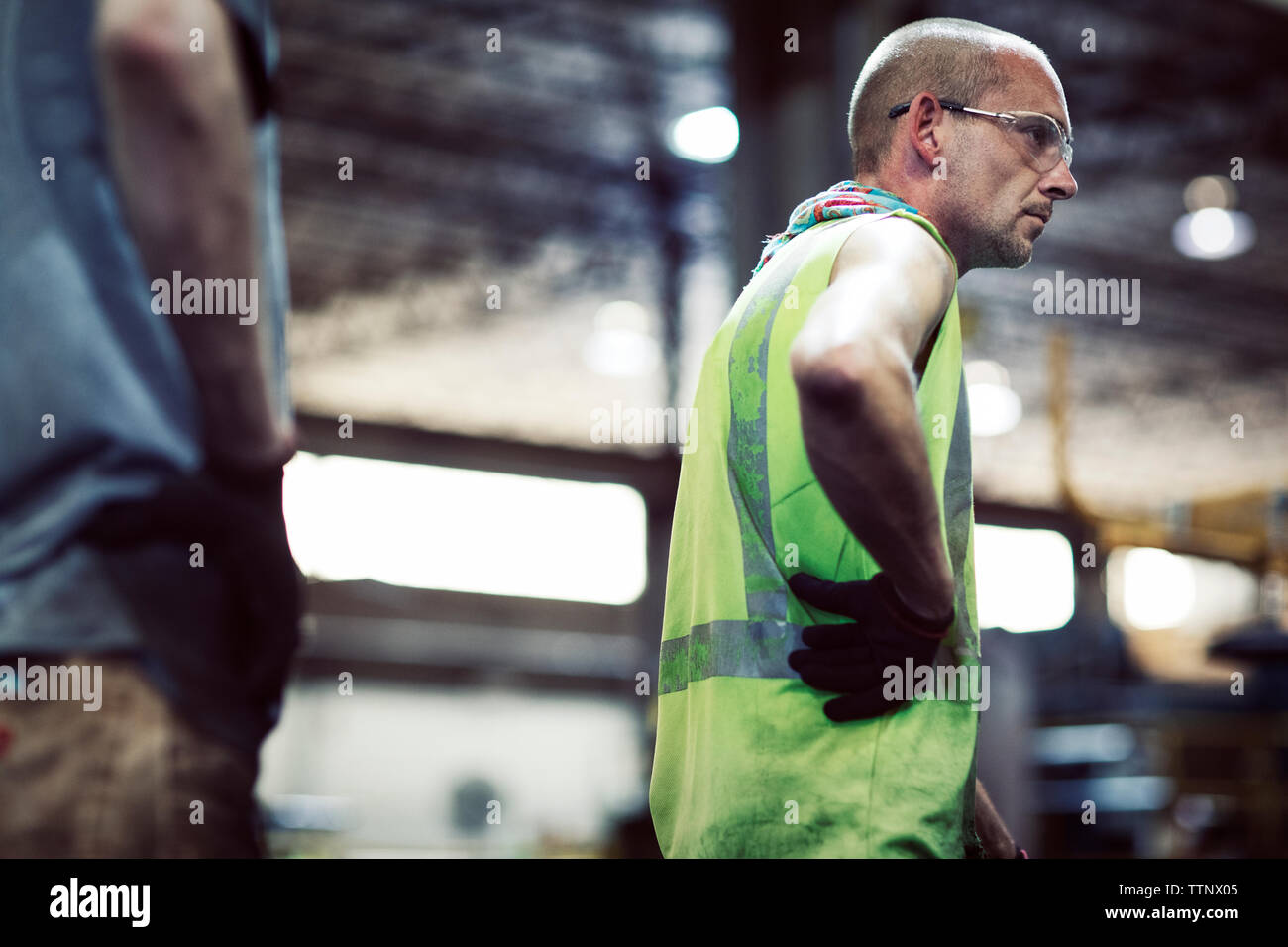 Side view of workers while standing in warehouse Stock Photo - Alamy