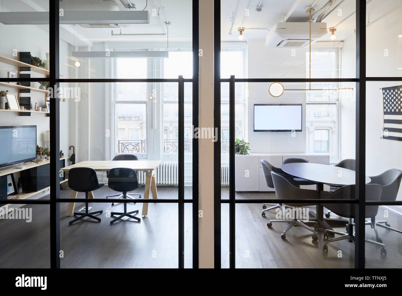 Furniture arranged in office seen through windows Stock Photo - Alamy