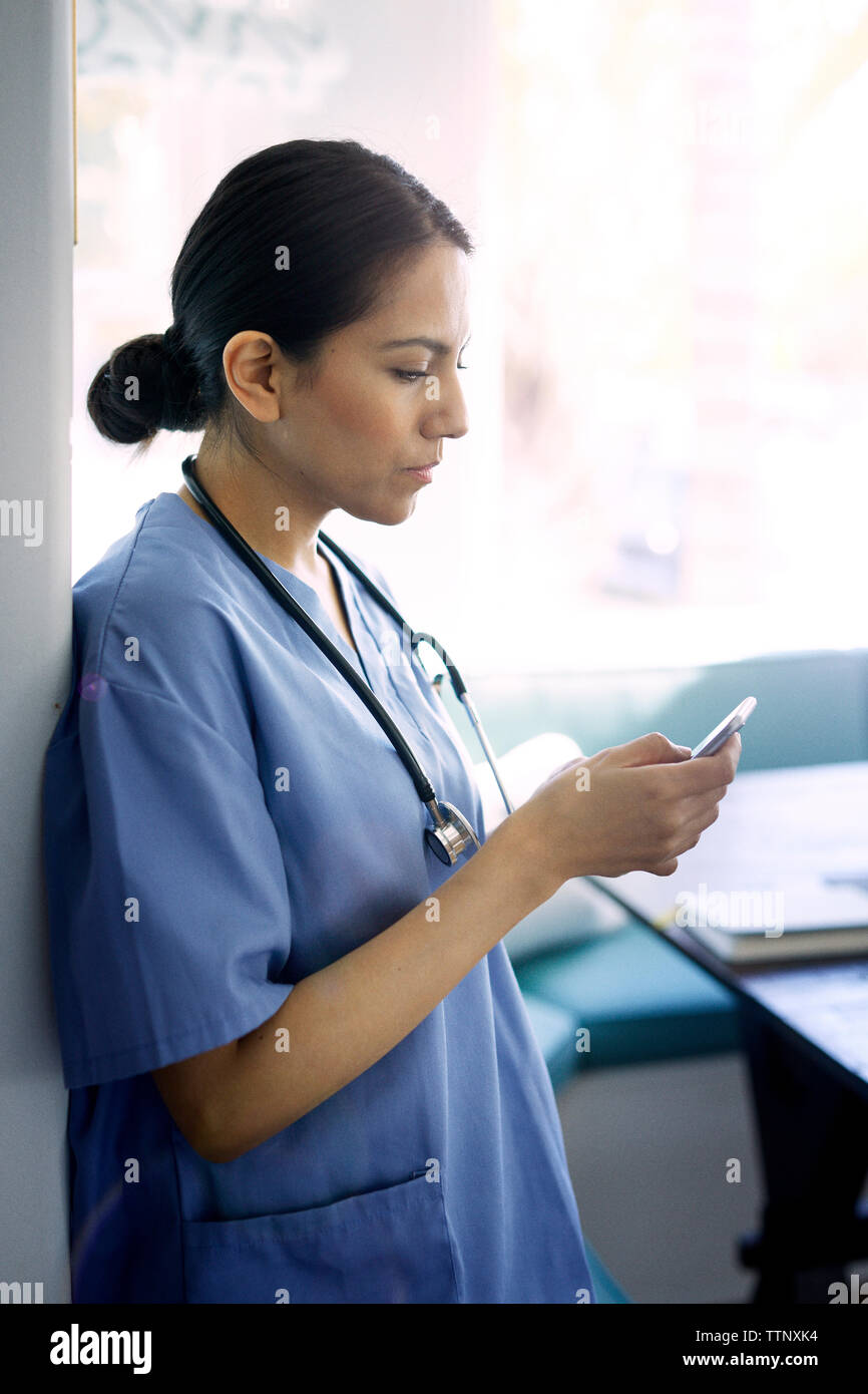Female doctor using smart phone while working in hospital Stock Photo ...