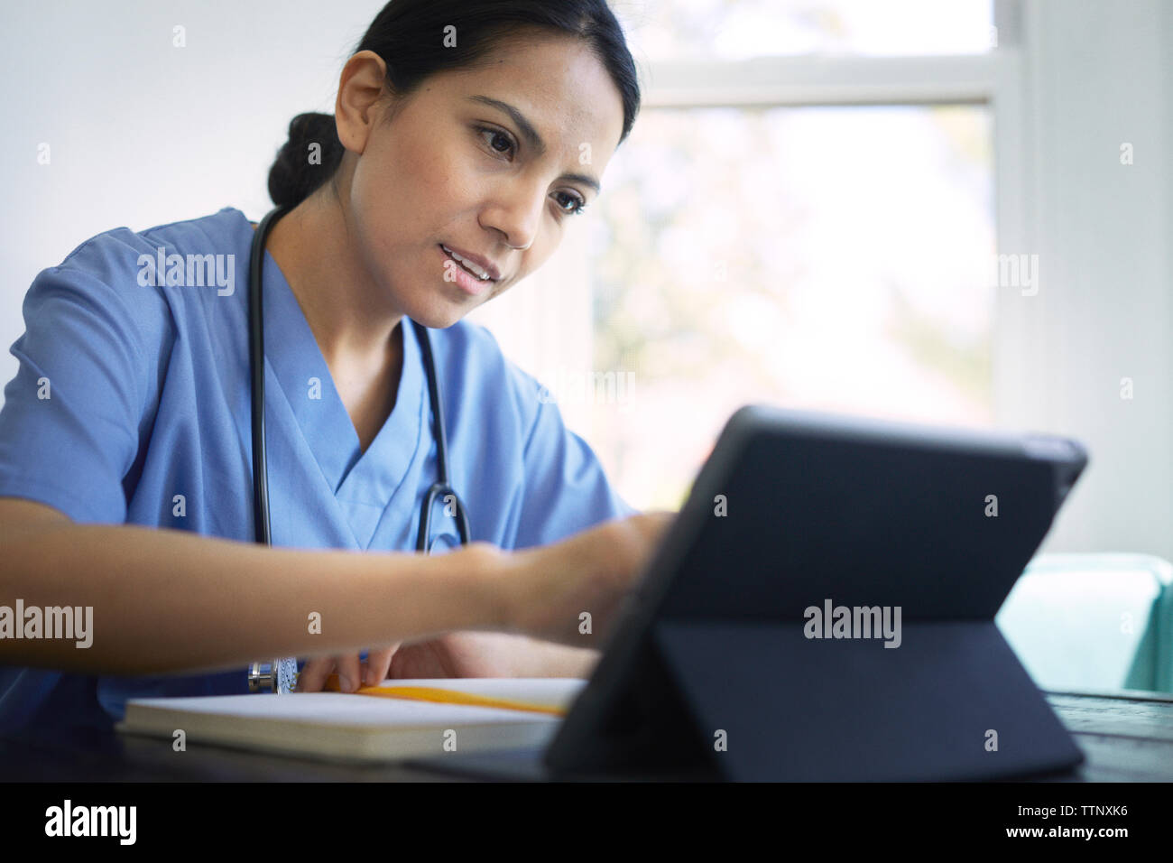 Female doctor using tablet computer while working in medical clinic ...