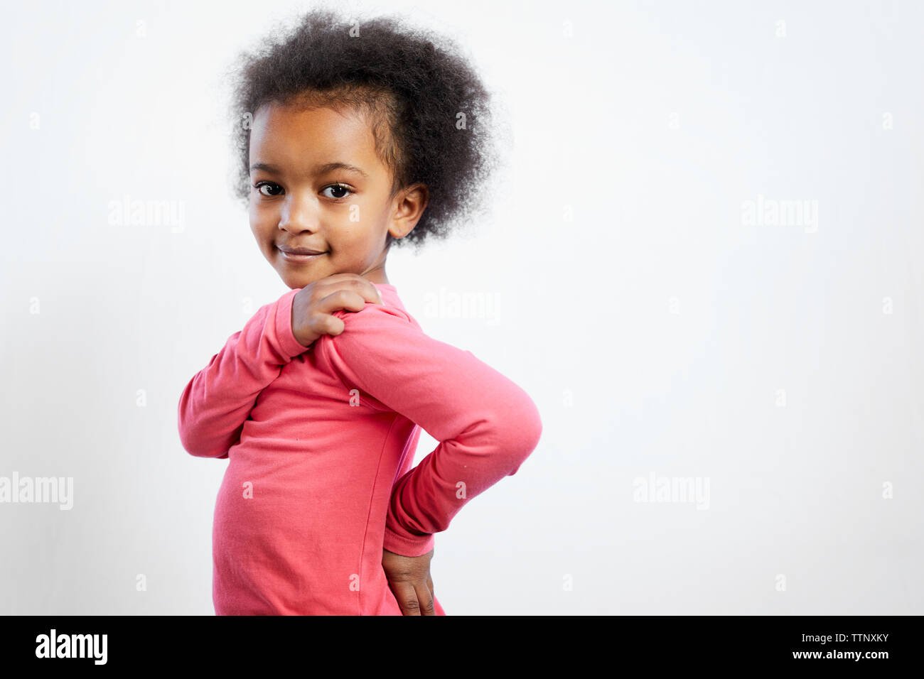 Portrait of smiling girl standing against white background Stock Photo ...
