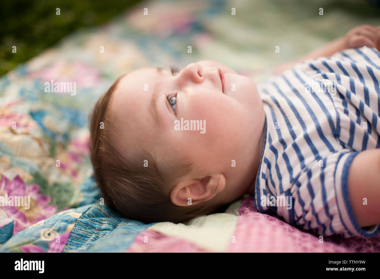 Side view of baby girl lying on blanket at lawn Stock Photo - Alamy