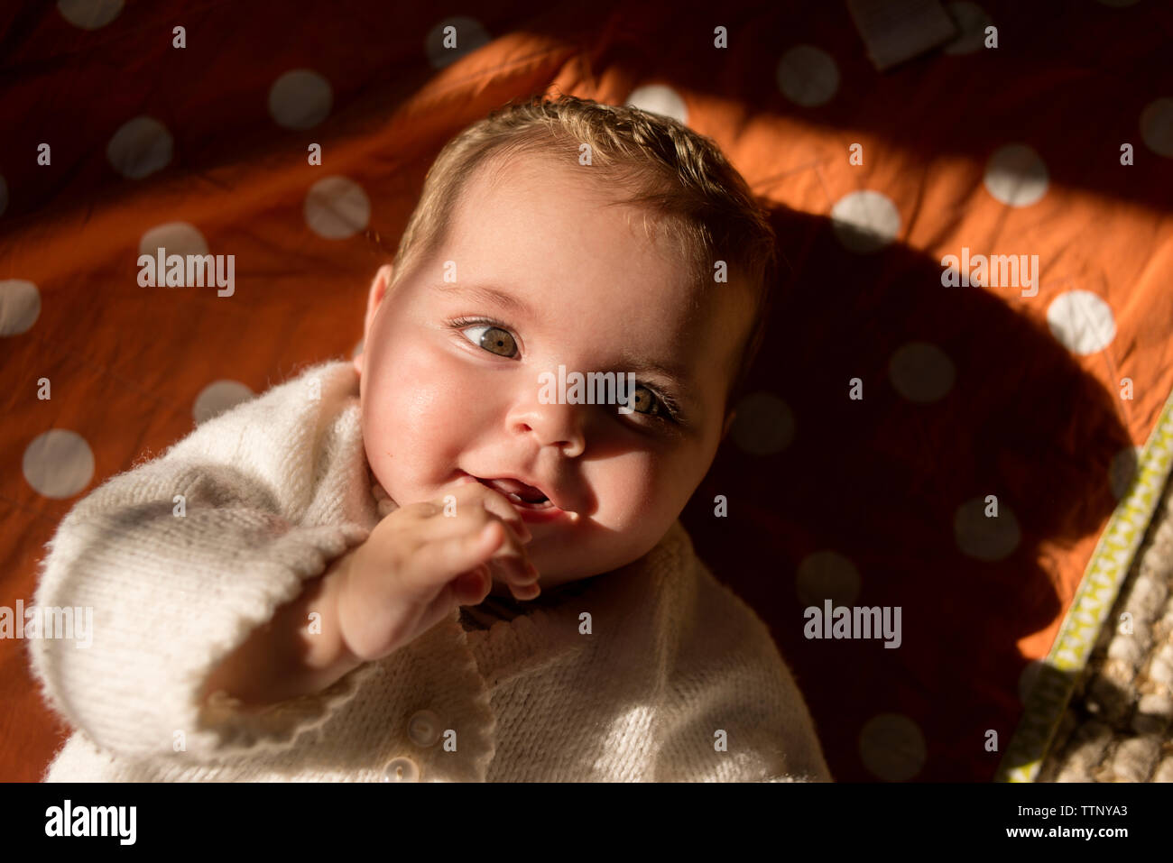 Overhead view of cute baby girl lying on bed Stock Photo - Alamy