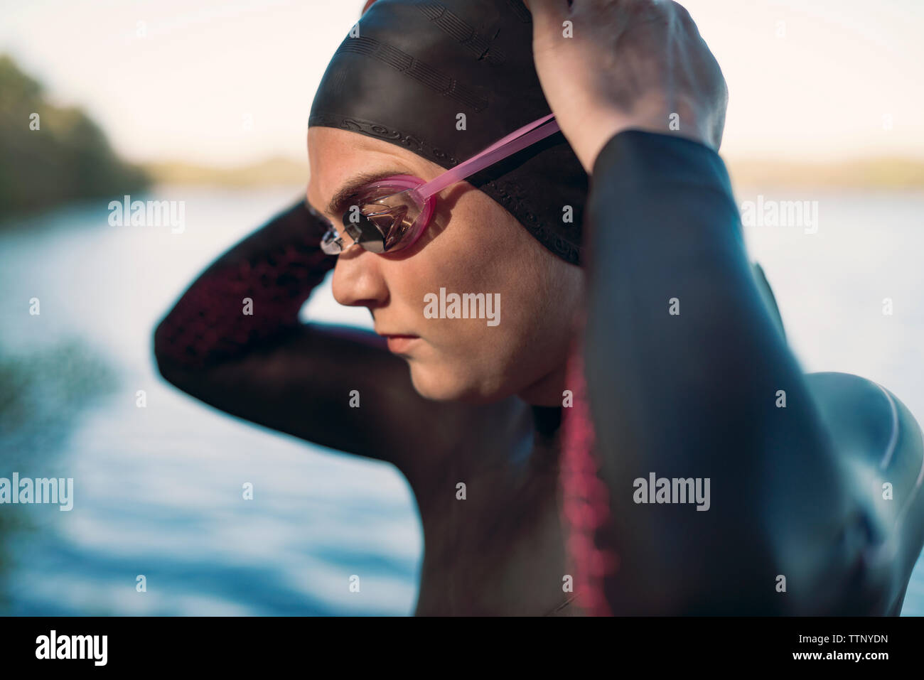Close-up of female swimmer wearing swimming goggles at lakeshore Stock ...