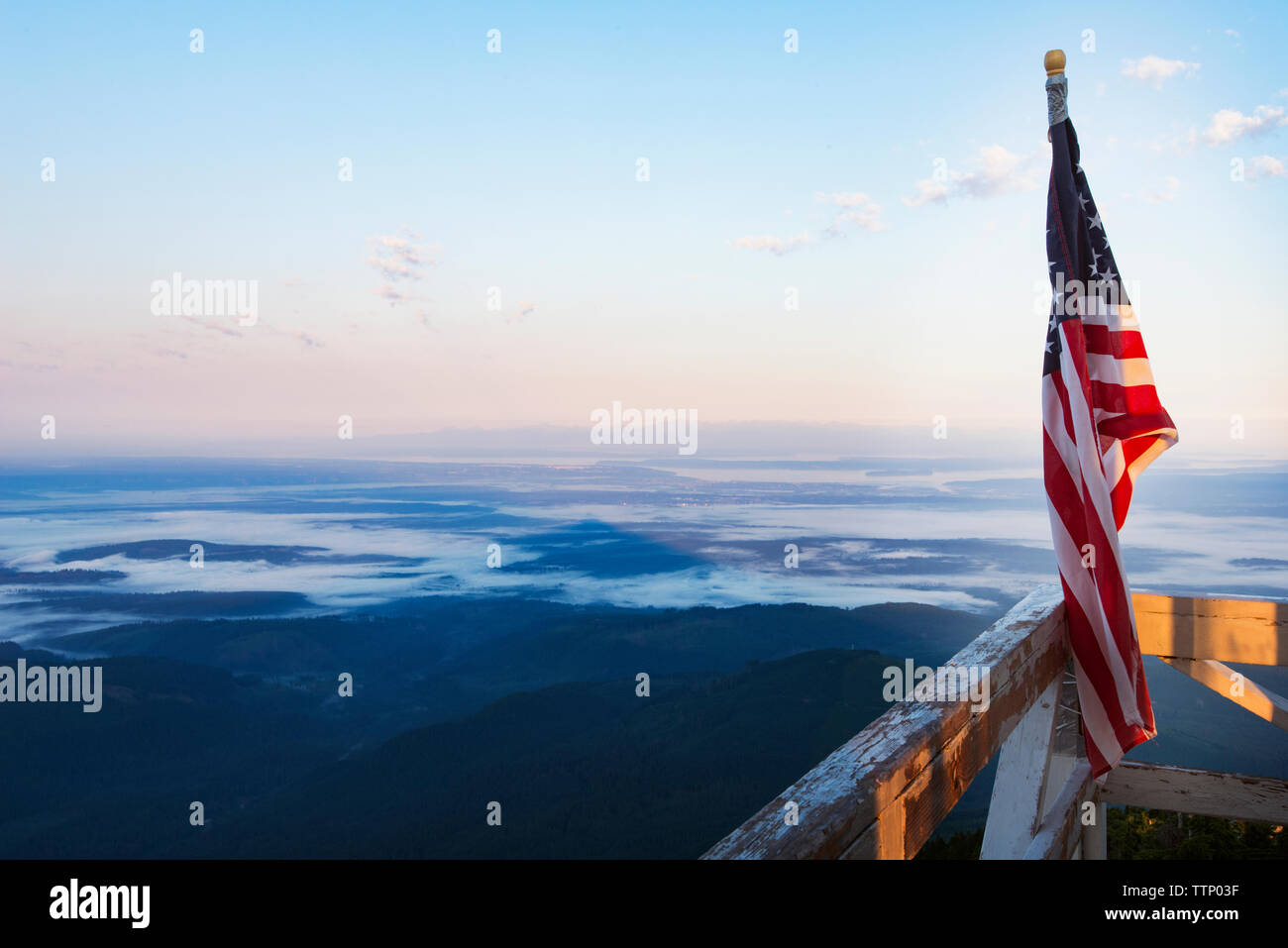 American flag on railing of fire lookout tower against landscape Stock ...