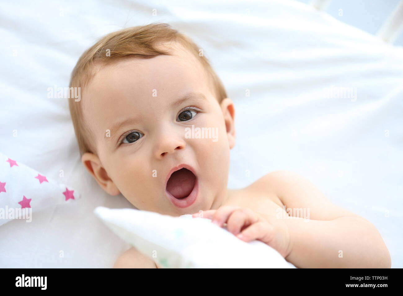 Cute baby with soft toys lying in the bed Stock Photo - Alamy